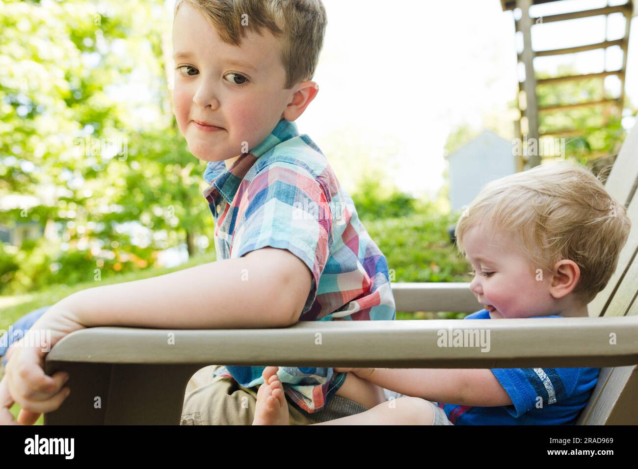 Younger brother tries to push older brother out of chair in backyard ...