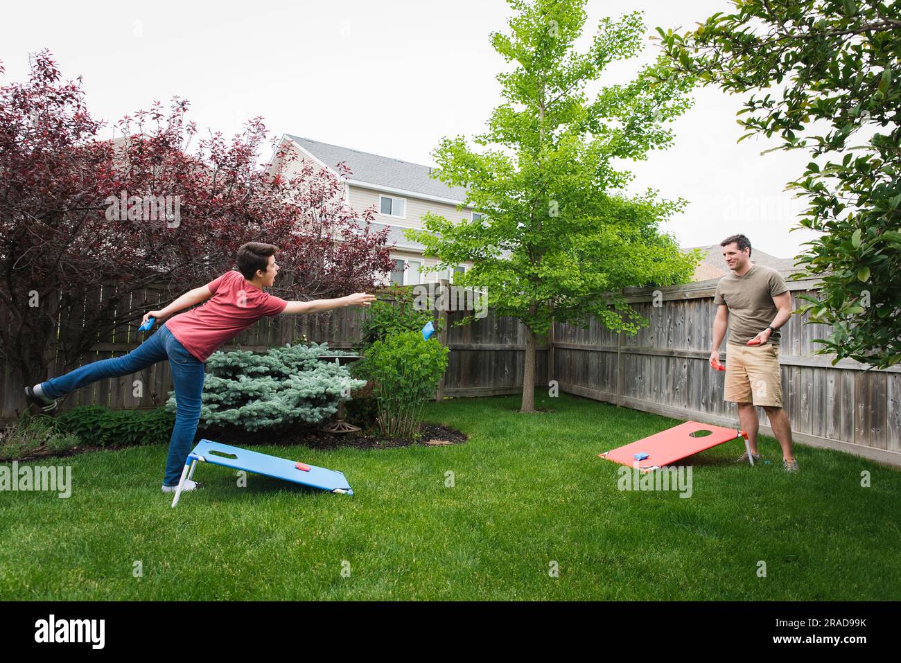 Father and son playing corn hole game in the backyard together Stock ...