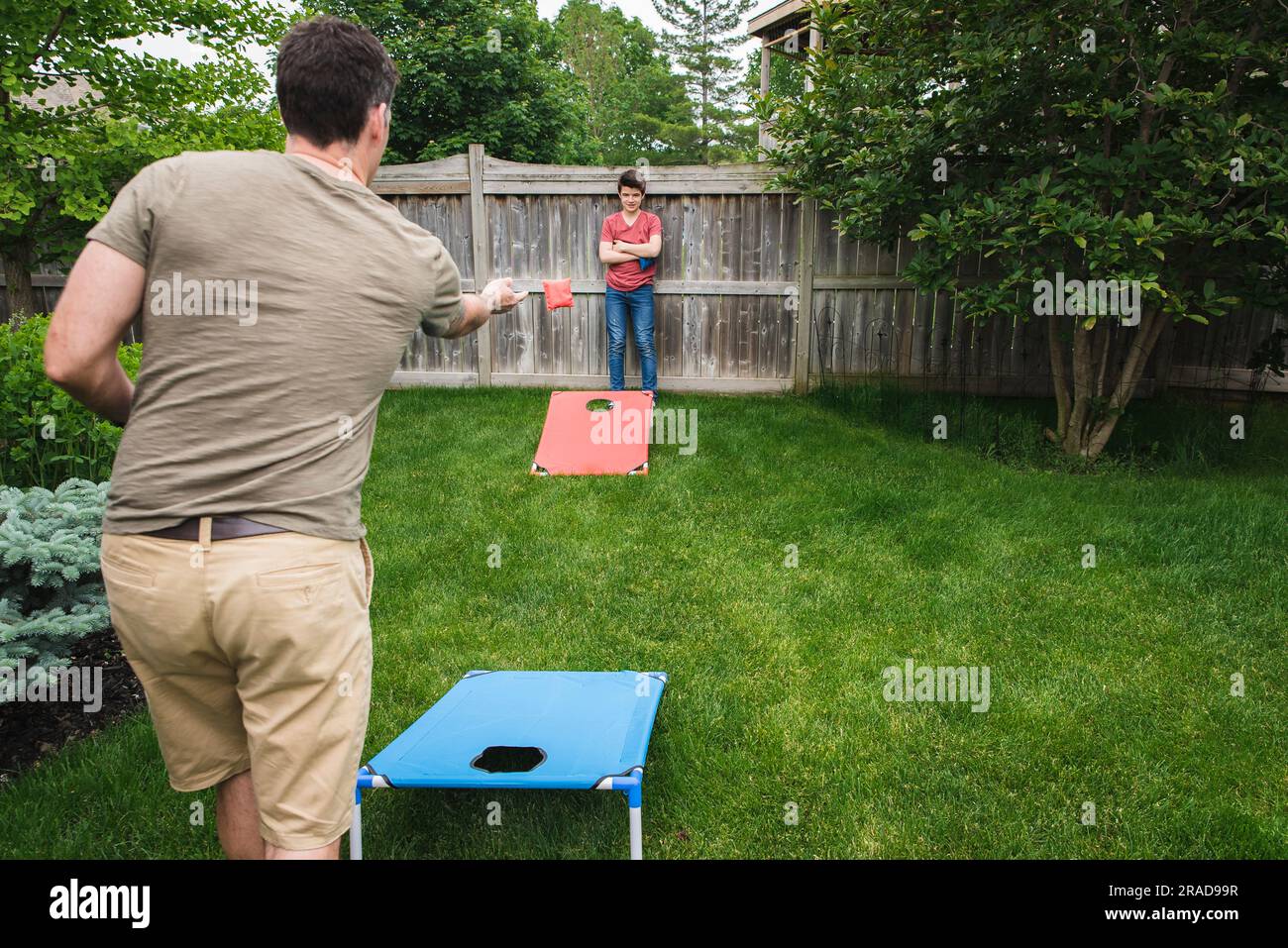 Father and son playing corn hole game in the backyard together Stock ...