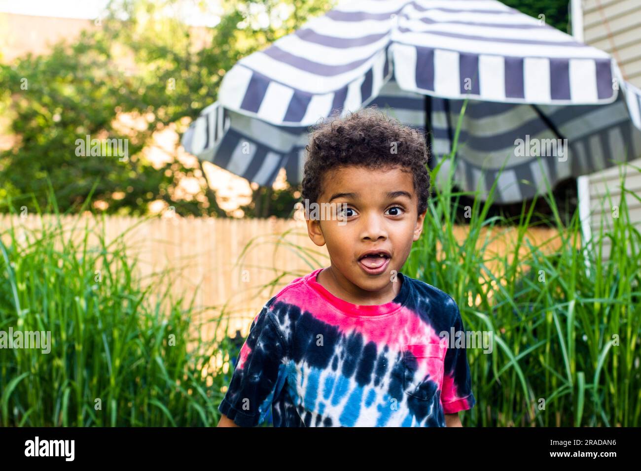 Little boy in backyard goofing around Stock Photo - Alamy