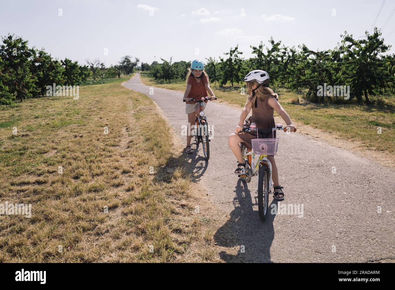 two sisters ride a bike, orchard cherry orchard, country life Stock ...