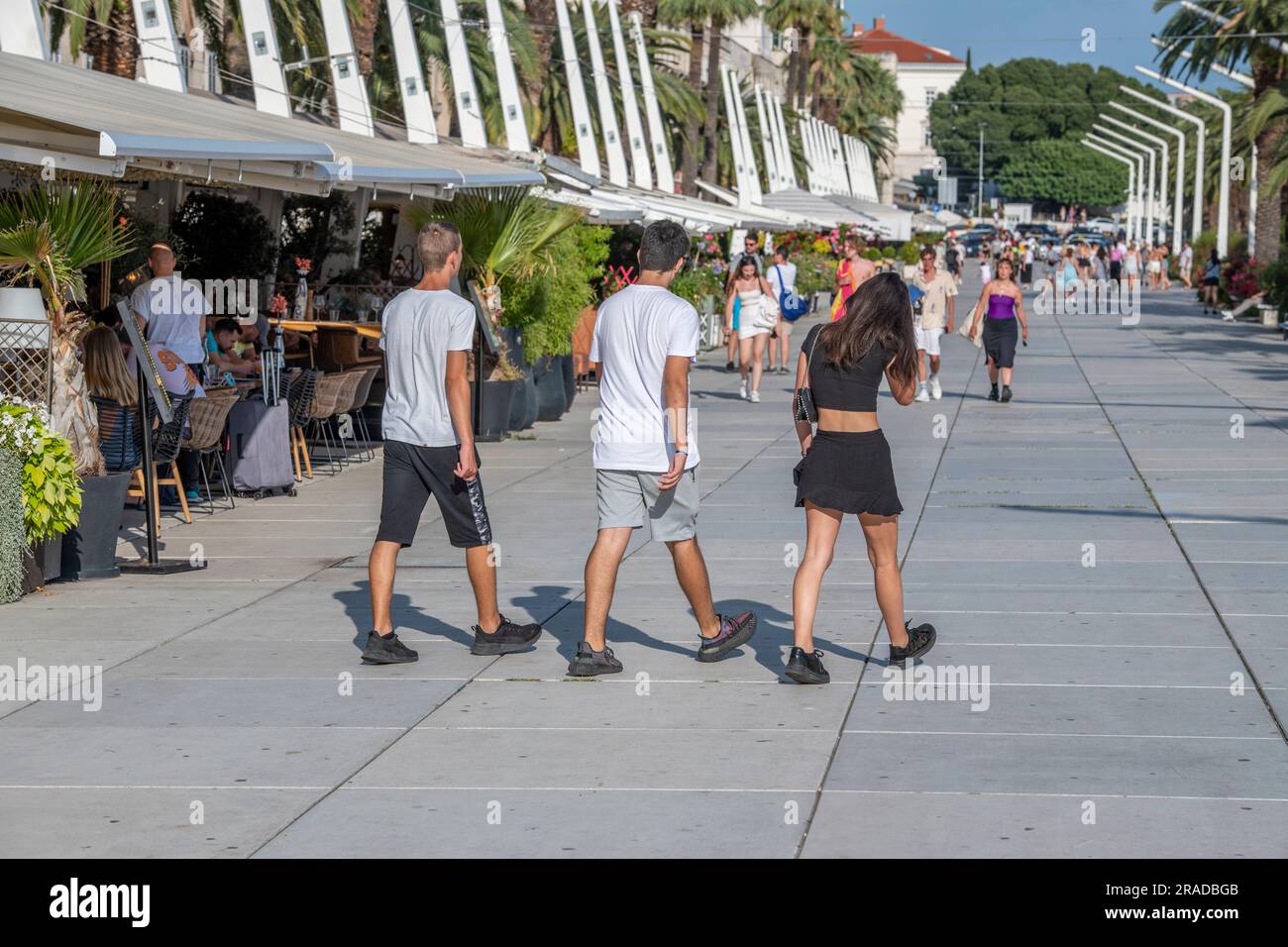 group of teenagers walking through the old town of grad split in ...