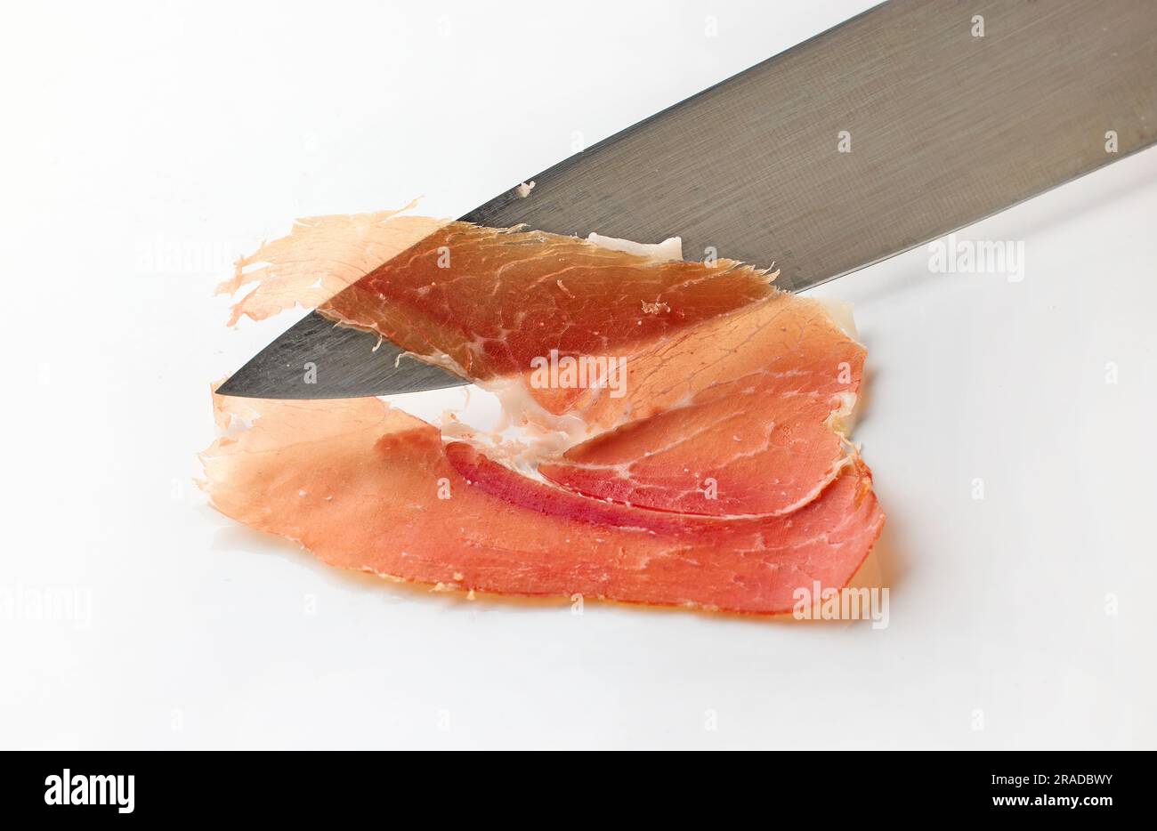 sliced spanish iberico ham and knife on white background Stock Photo ...