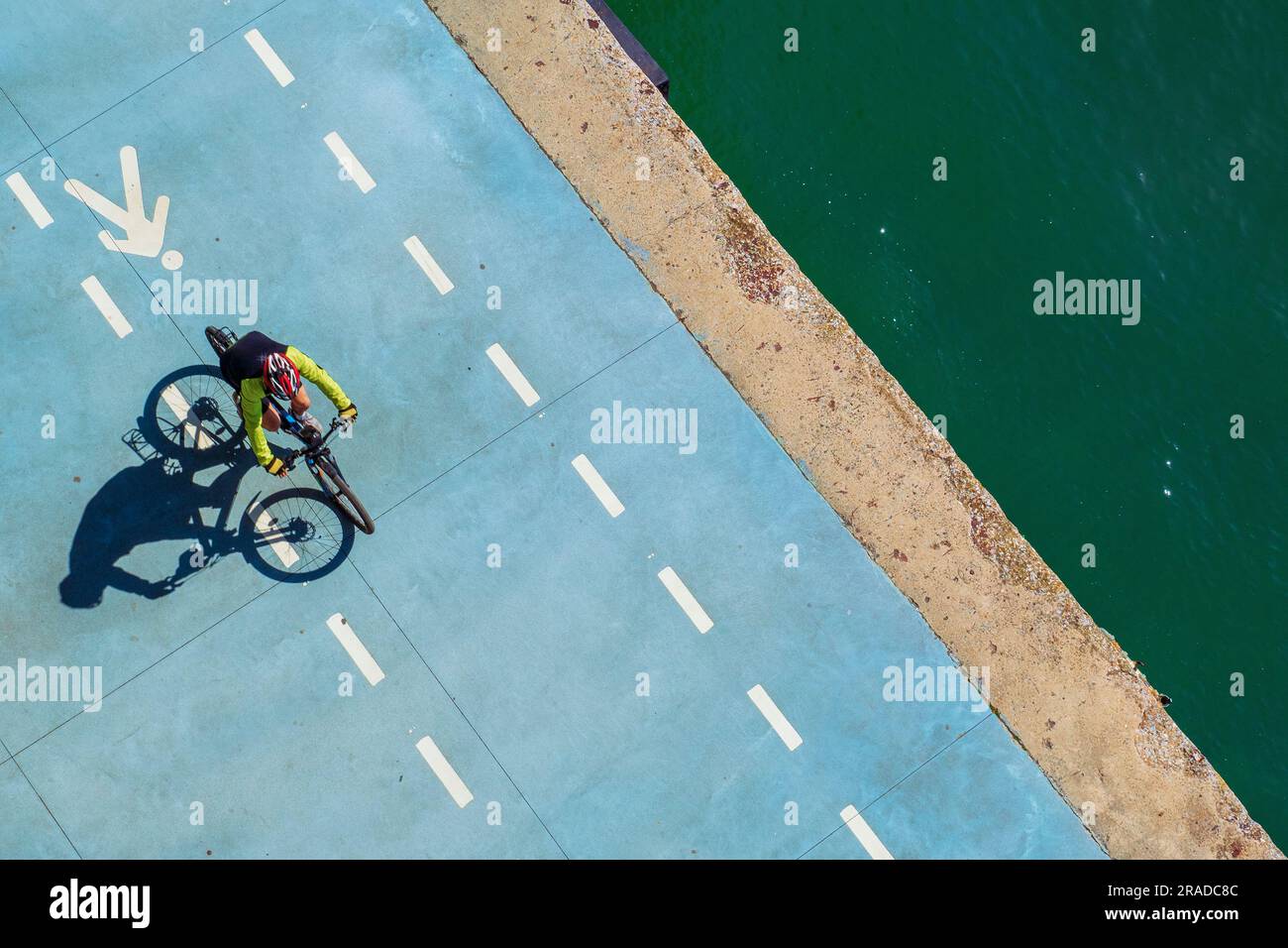 Cyclist riding along the cycle path in the port of Santander, Spain ...