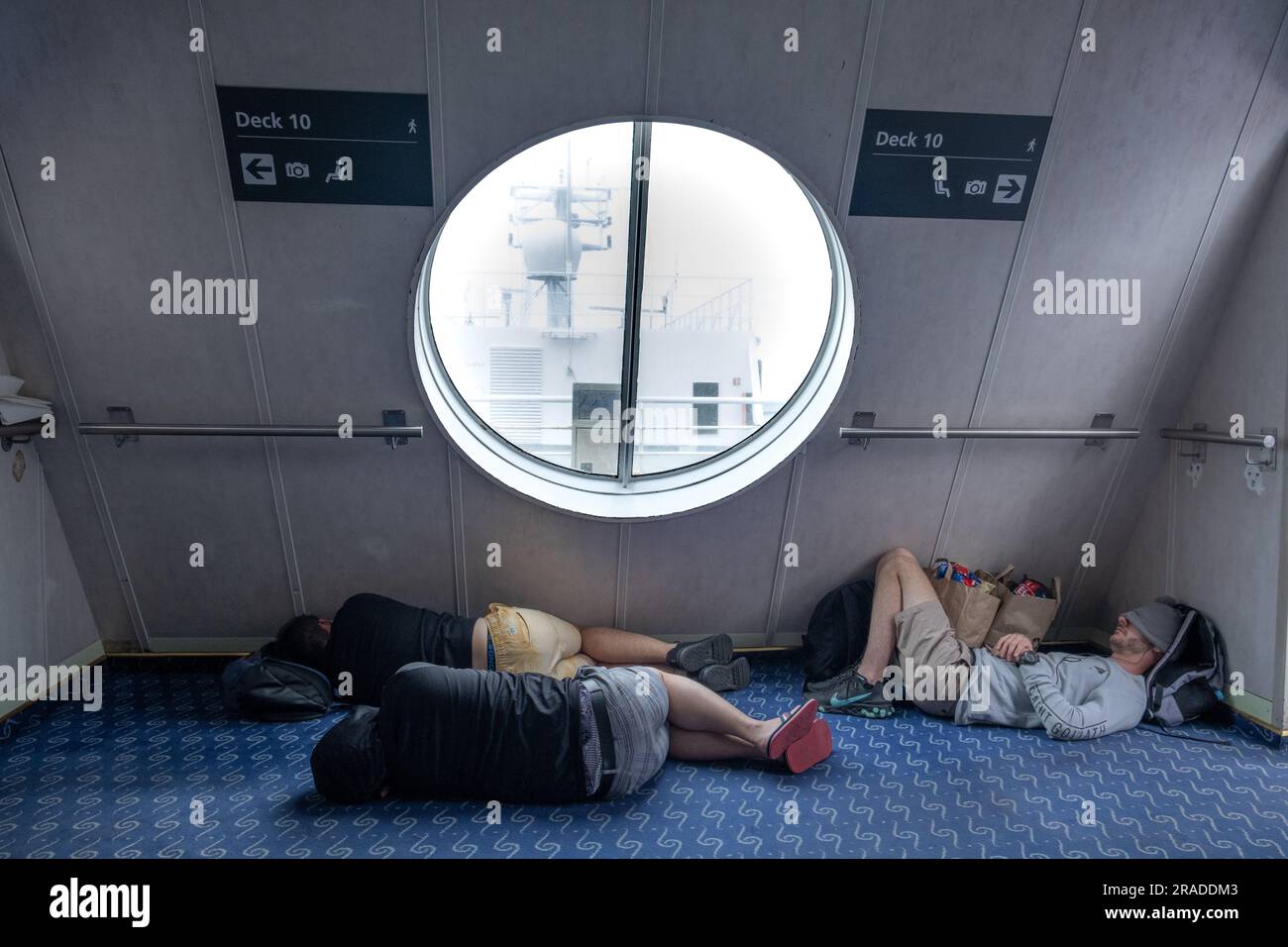 Travellers sleeping on the floor in a corridor on a packed Wellington ...