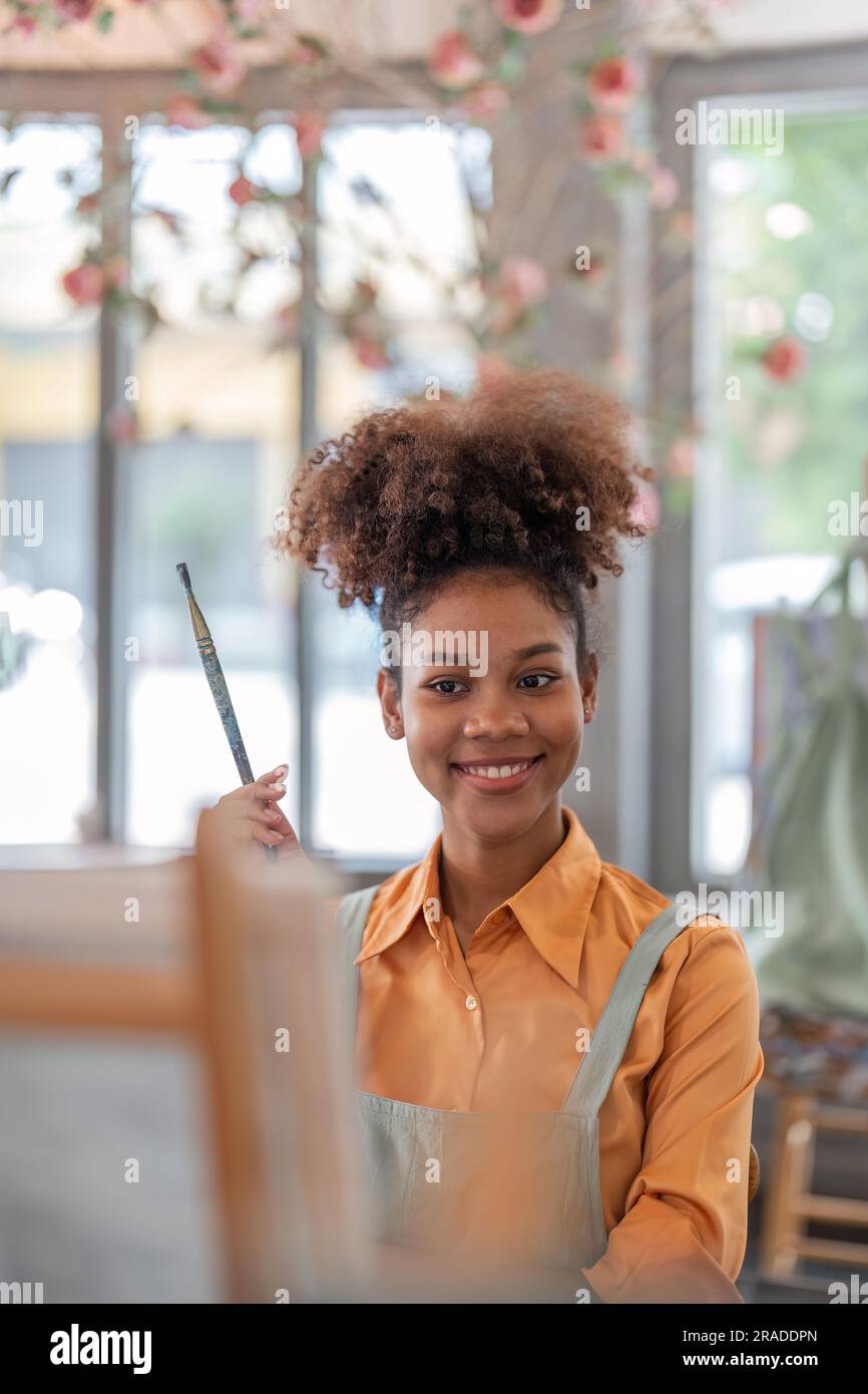 african american female artist painting on canvas doing some art ...