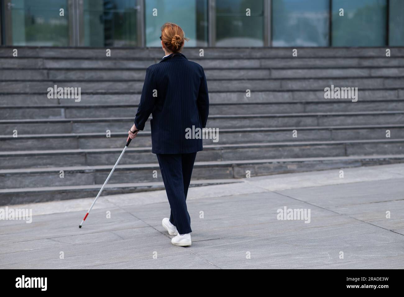 Blind businesswoman walking with tactile cane to business center Stock ...