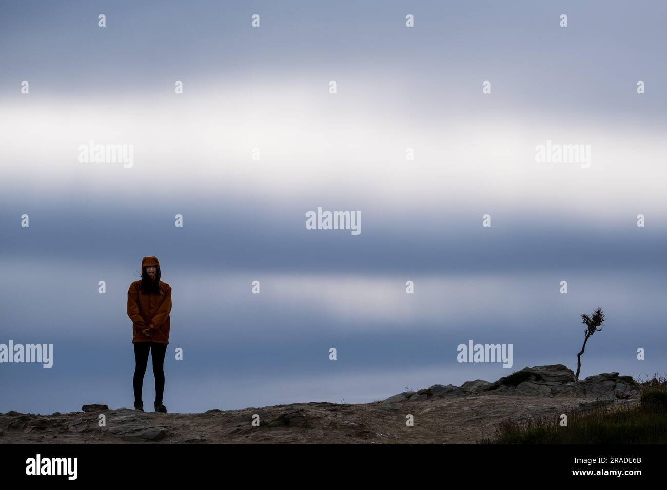 A woman posing on Crown Range Summit in a storm overlooking the ...