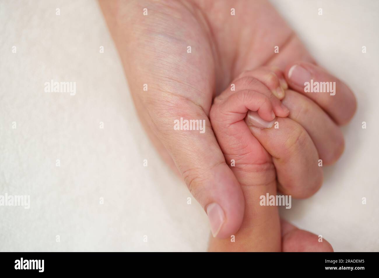 mother holding newborn baby hand on a bed Stock Photo - Alamy