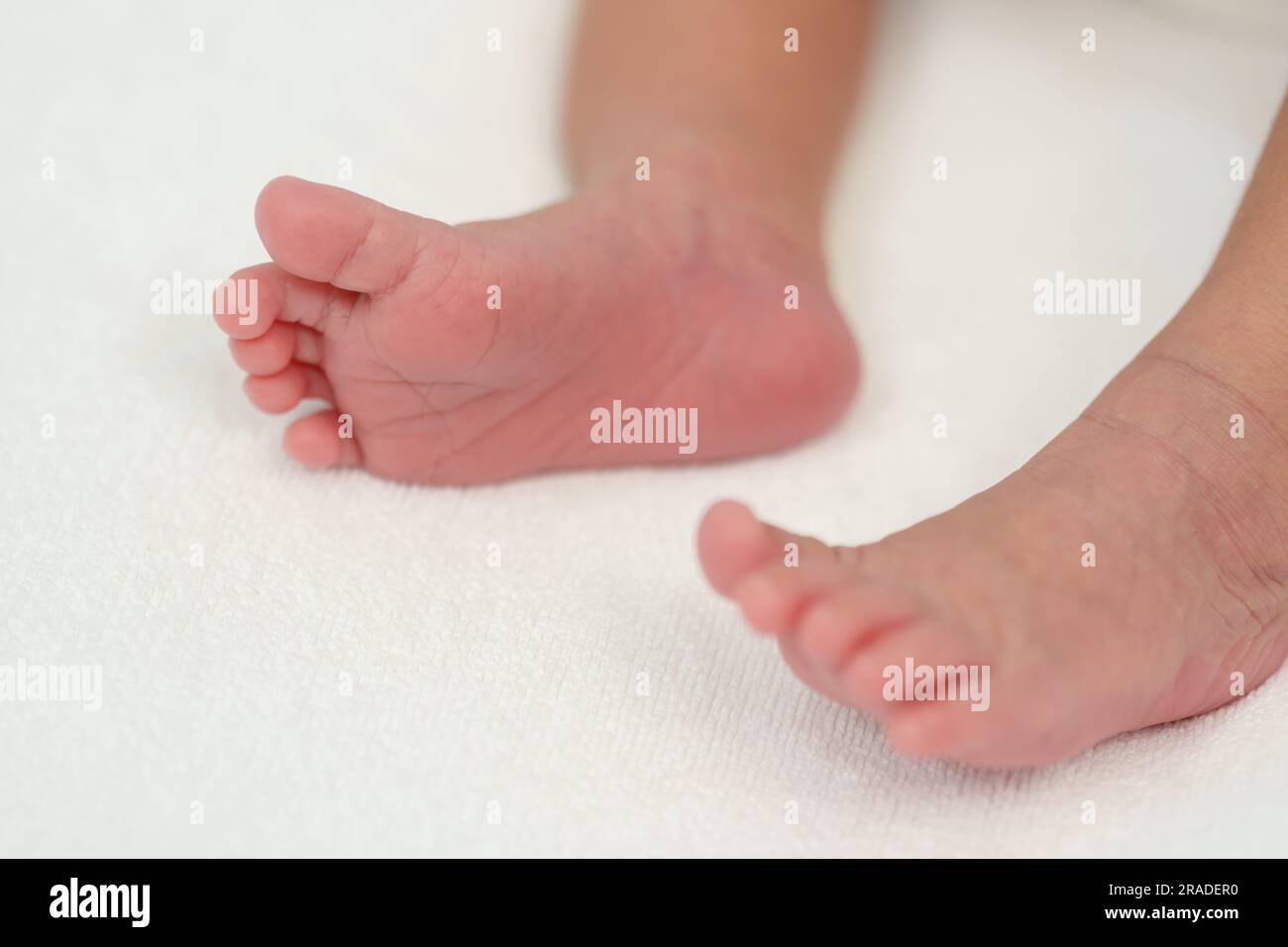 close up feet of newborn baby on a bed Stock Photo - Alamy