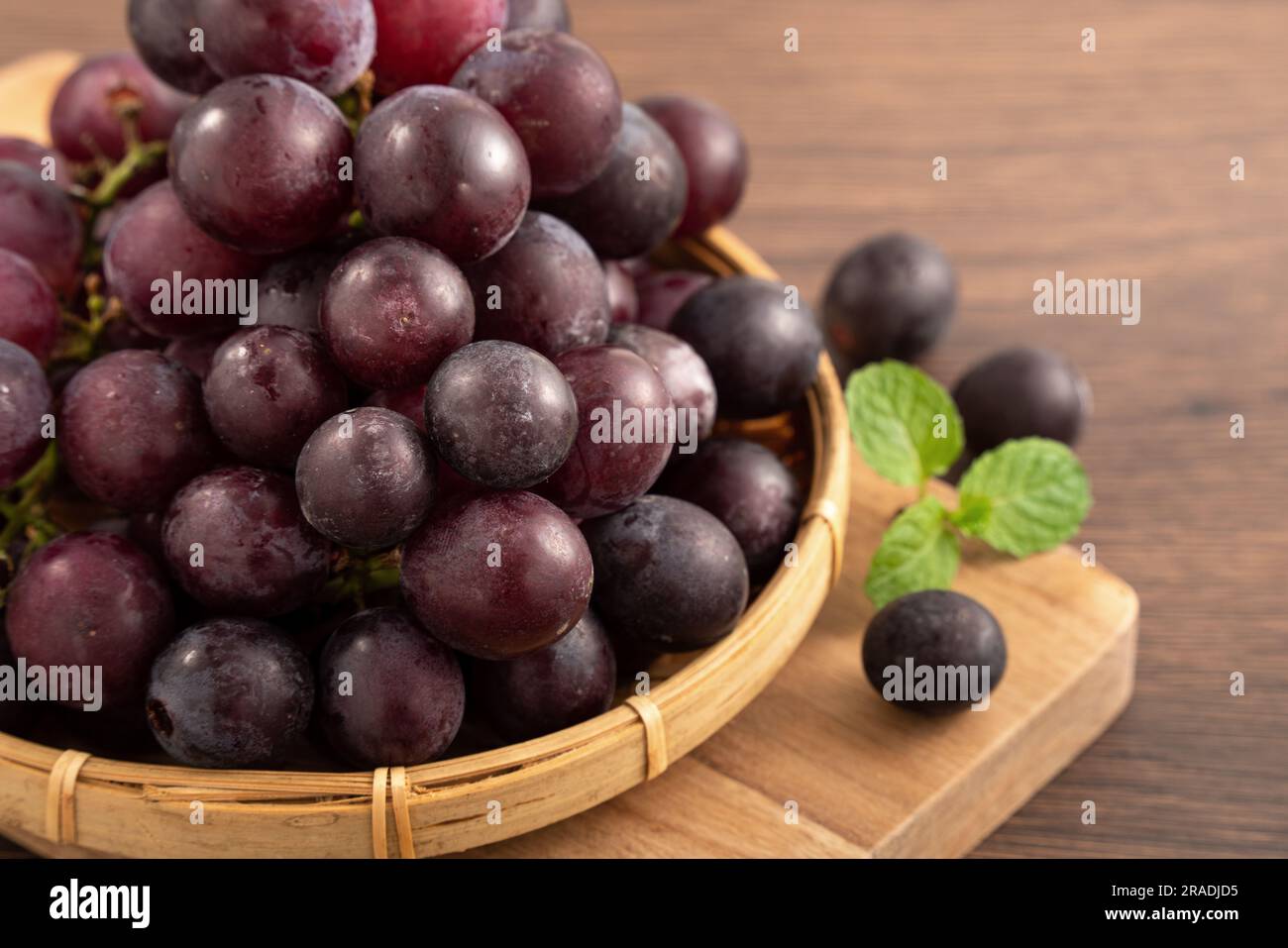 Delicious bunch of purple grapes fruit on a tray over wooden table ...