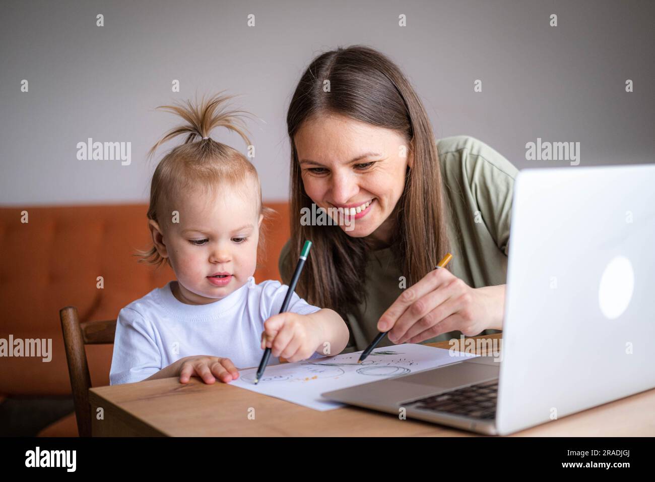 happy family mother and little baby daughter do homework using laptop ...