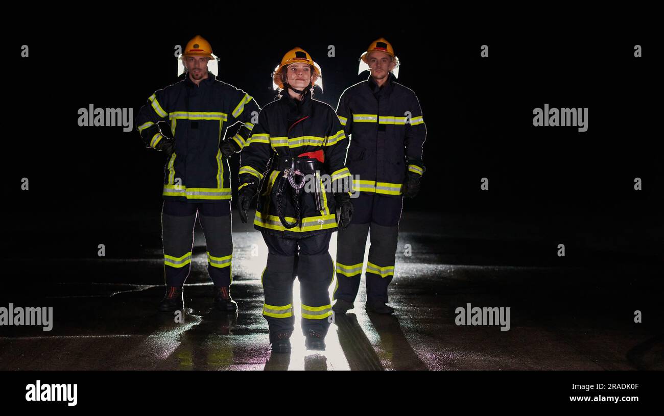 A group of professional firefighters marching through night on a rescue ...
