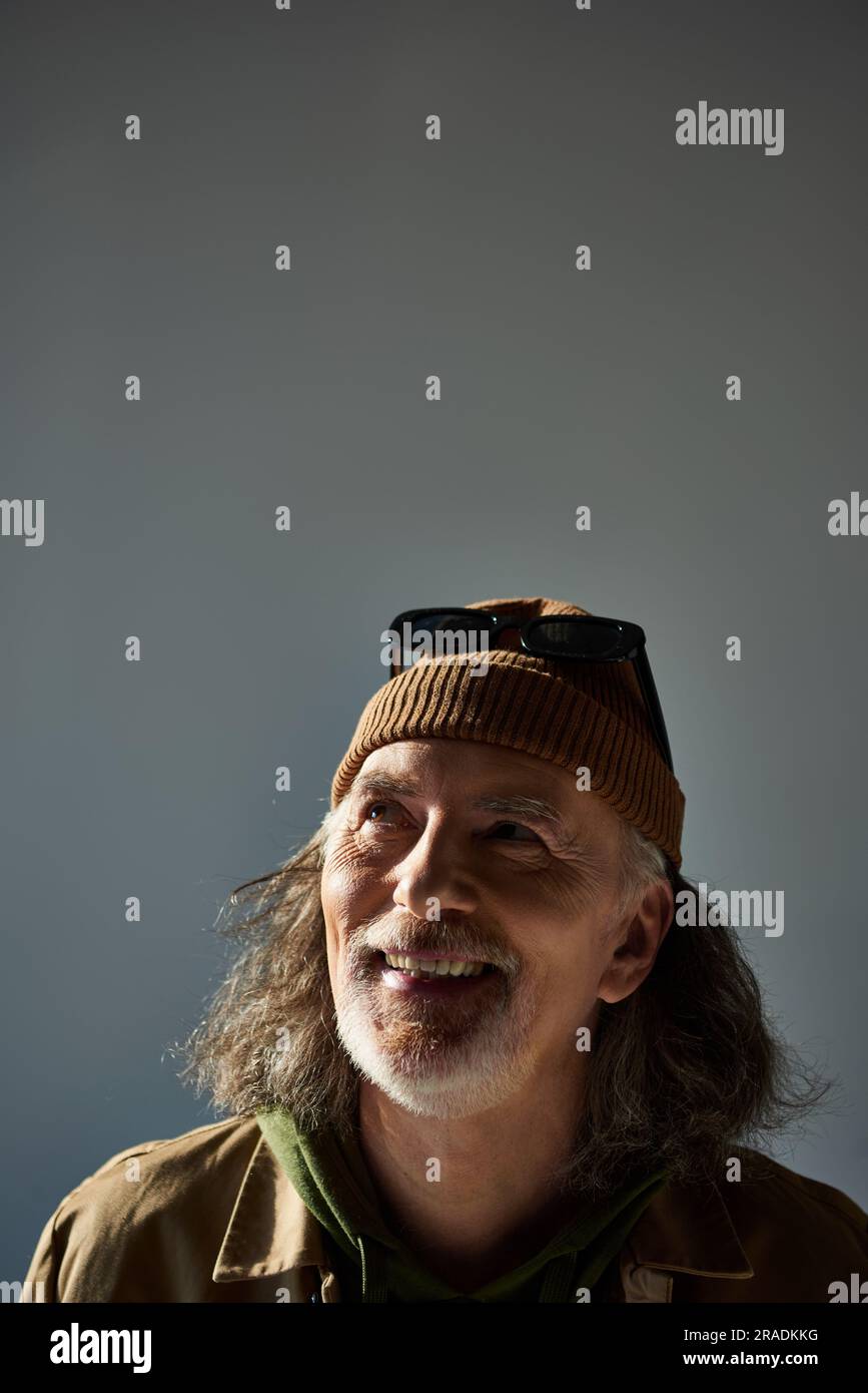 portrait of cheerful and carefree senior man with grey hair and beard ...