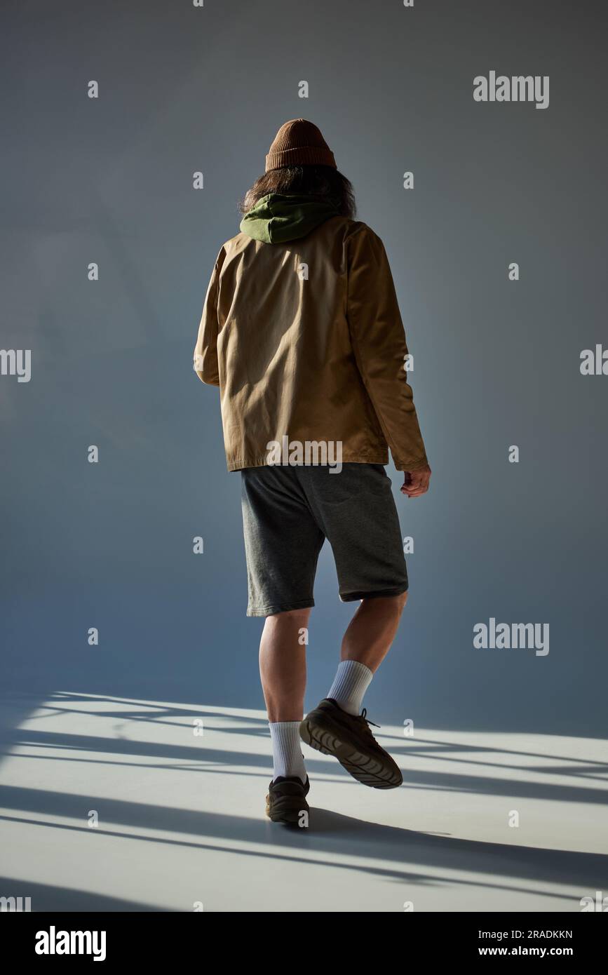 back view of senior and fashionable man in beanie hat, jacket and ...