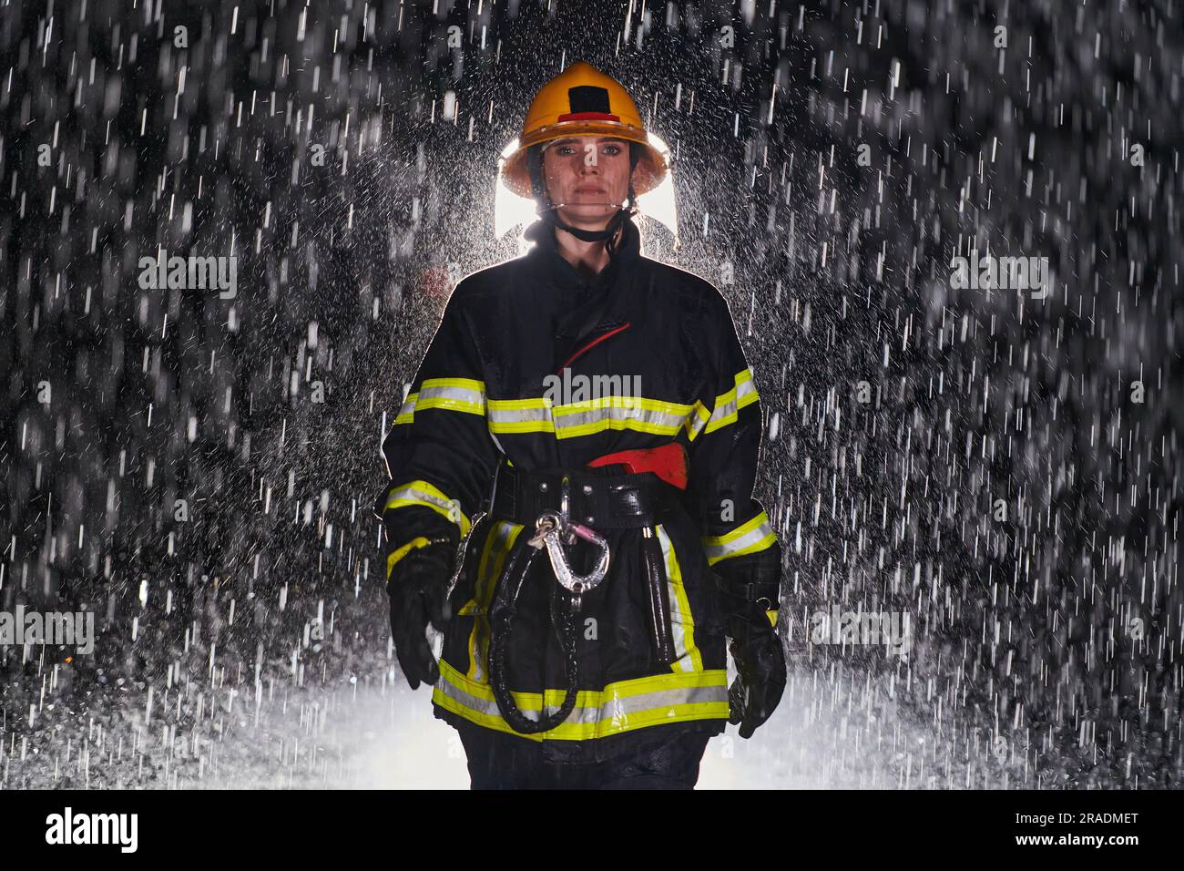 A determined female firefighter in a professional uniform striding ...