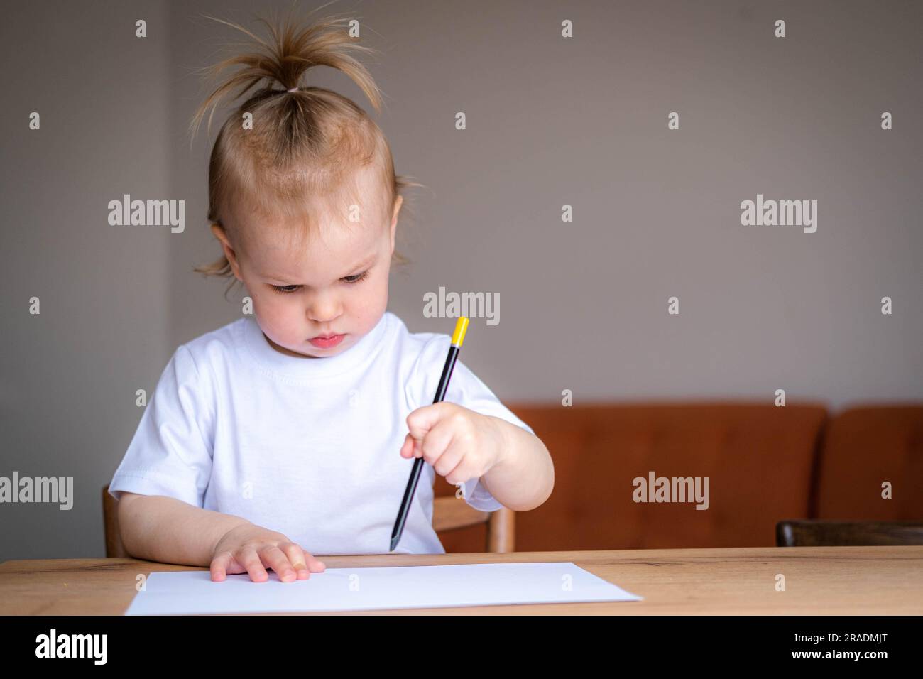 baby girl paint or writing at home in sunny cozy living room ...