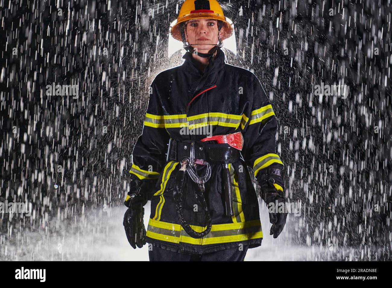 A determined female firefighter in a professional uniform striding ...
