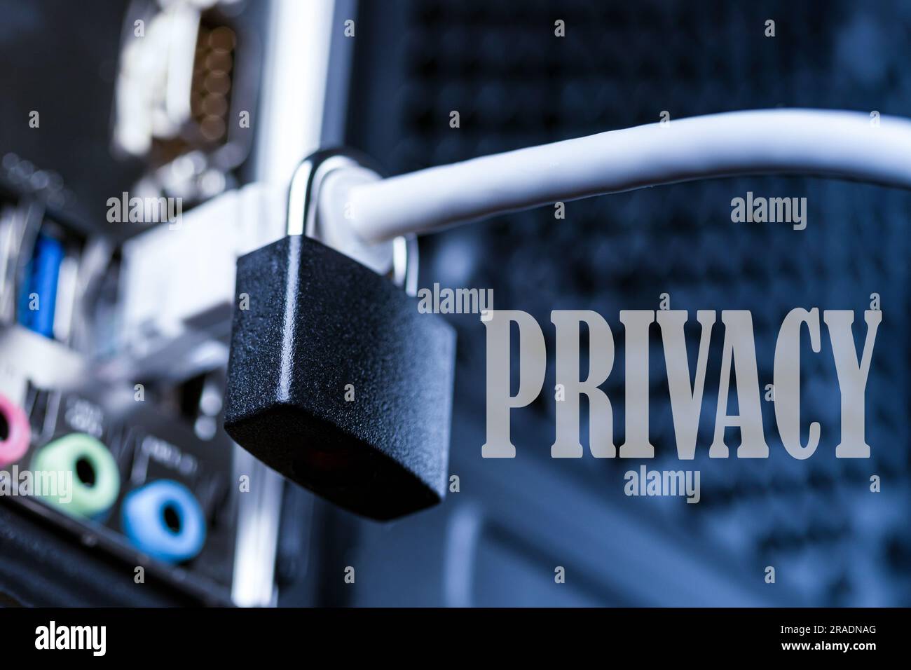 Closed lock hanging on a network cable plugged into a computer. The ...
