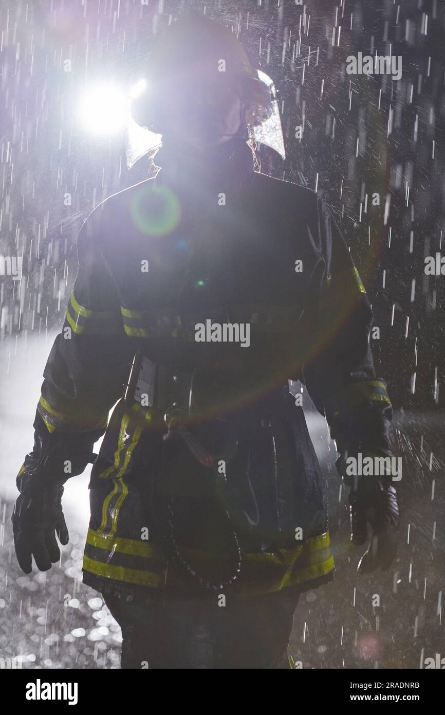 A determined female firefighter in a professional uniform striding ...