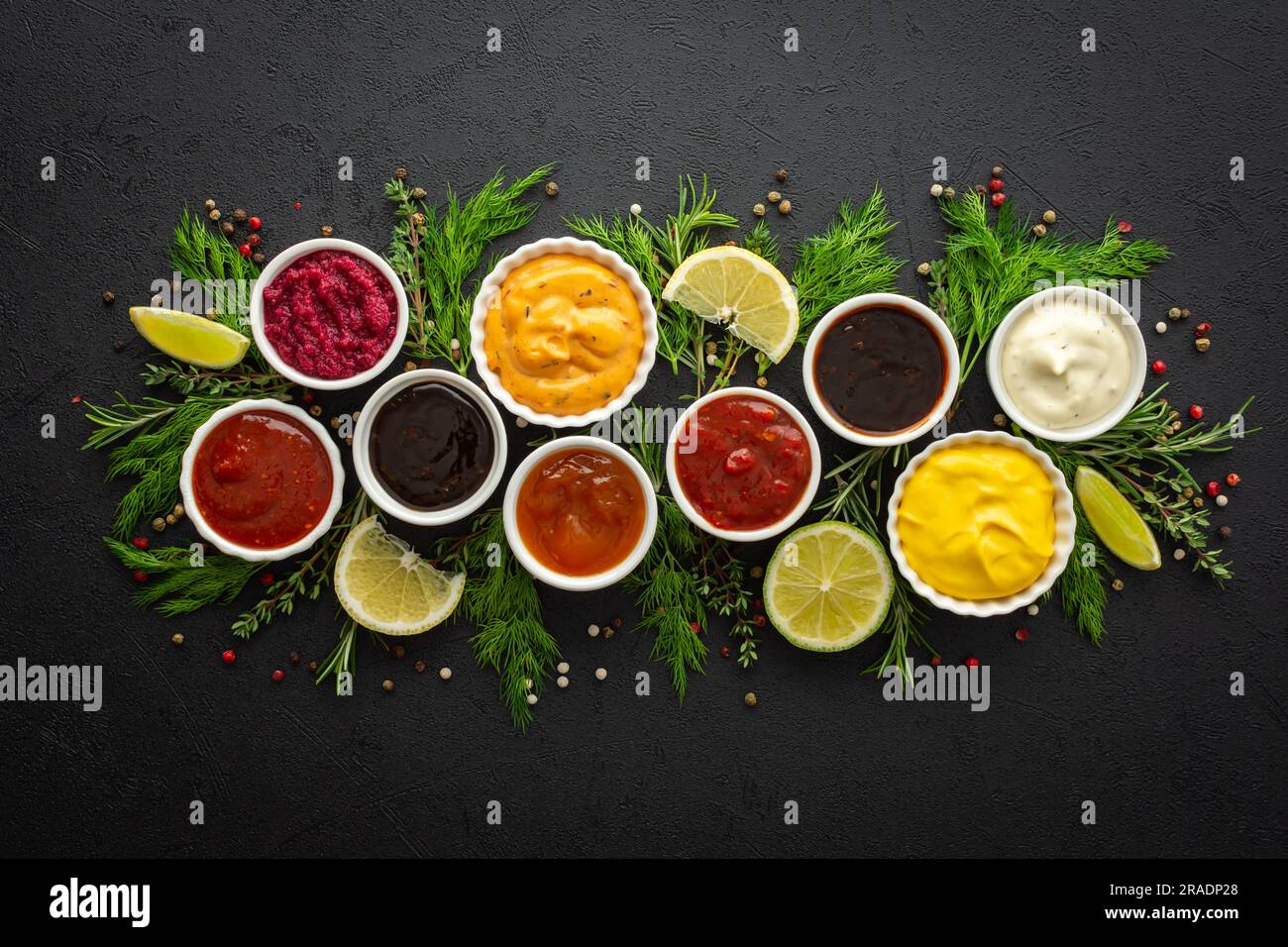 Different types of sauces in bowls with seasonings, rosemary and dill ...