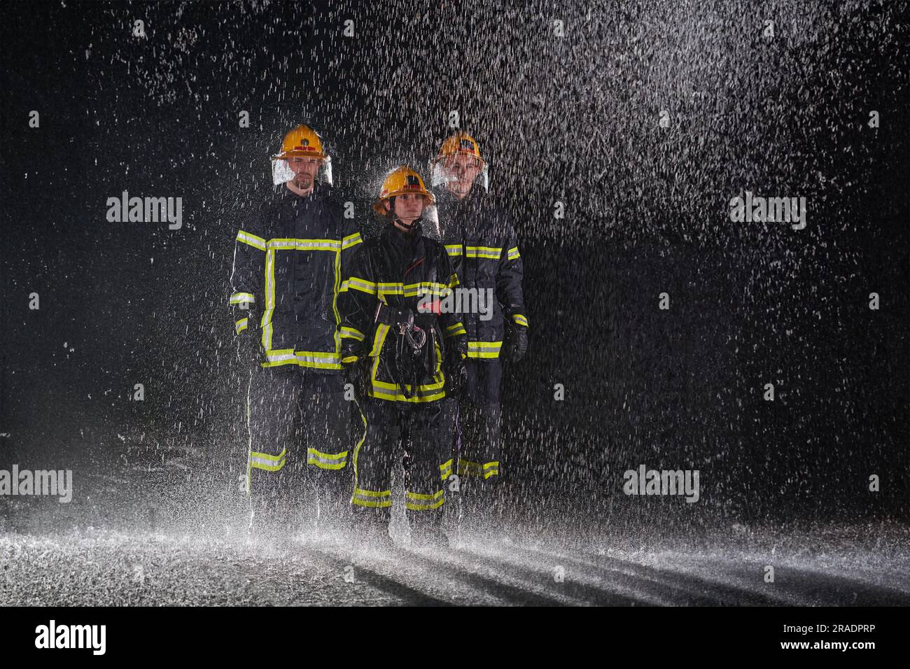 A group of professional firefighters marching through the rainy night ...