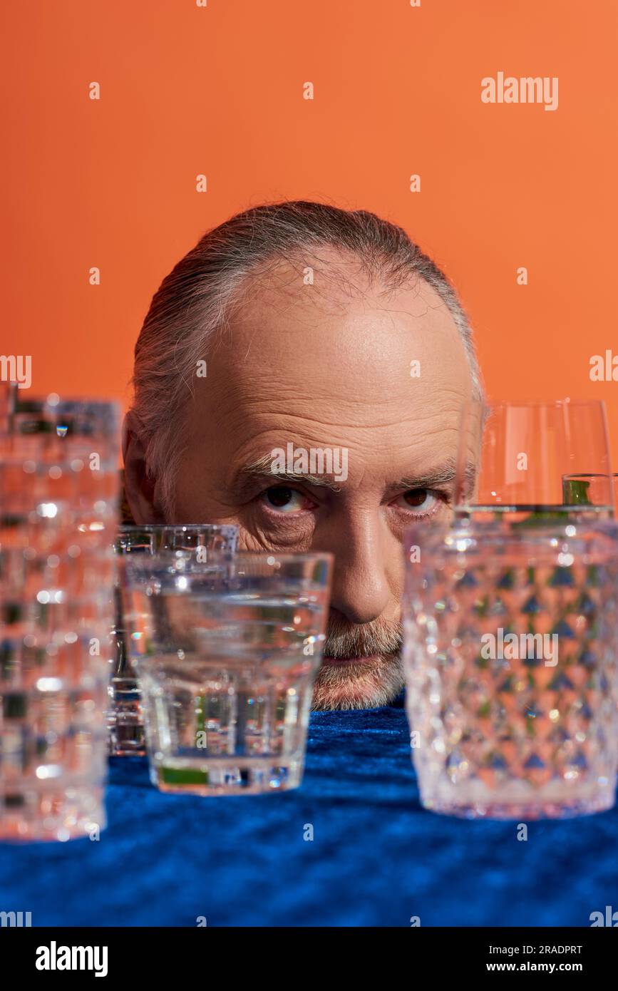 portrait of senior grey haired man with expressive gaze looking at ...