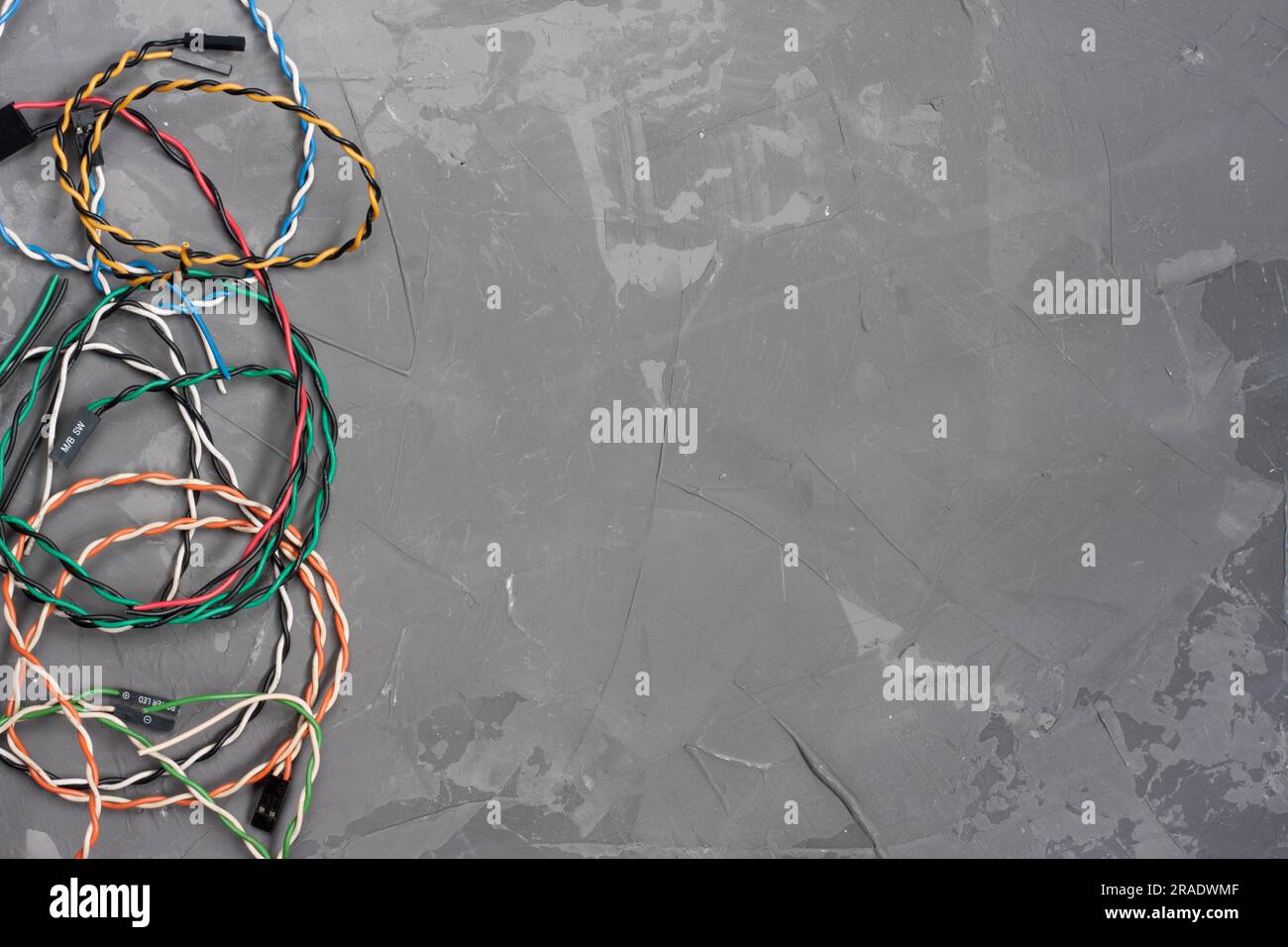 Colored cables and wires with connectors on gray concrete background ...