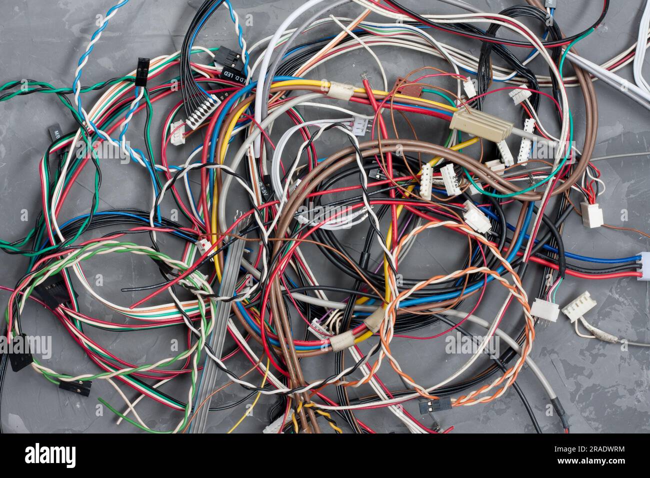 Colored cables and wires with connectors on gray concrete background ...