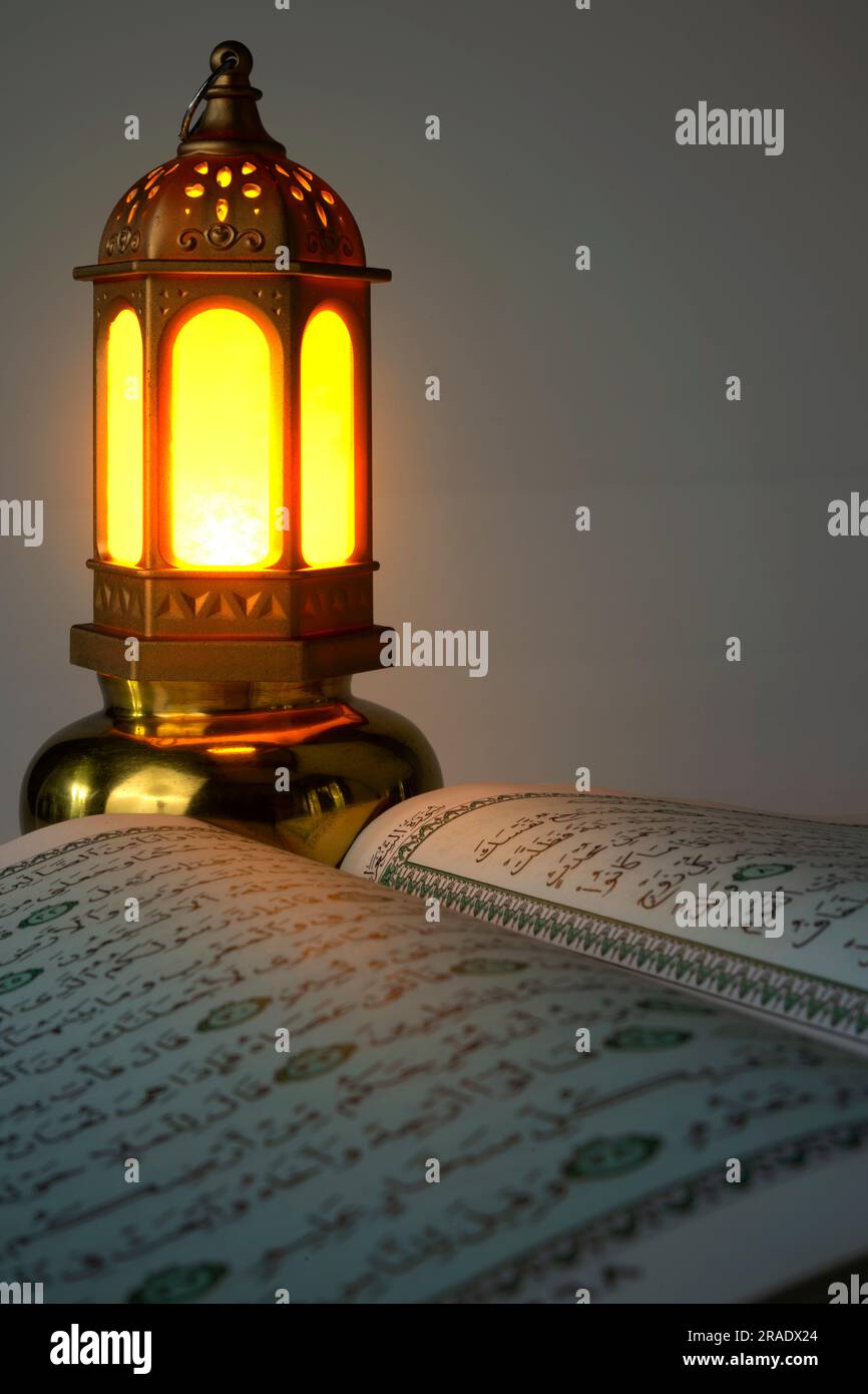 Quran and Arabic lamp with bright light with dark background Stock ...