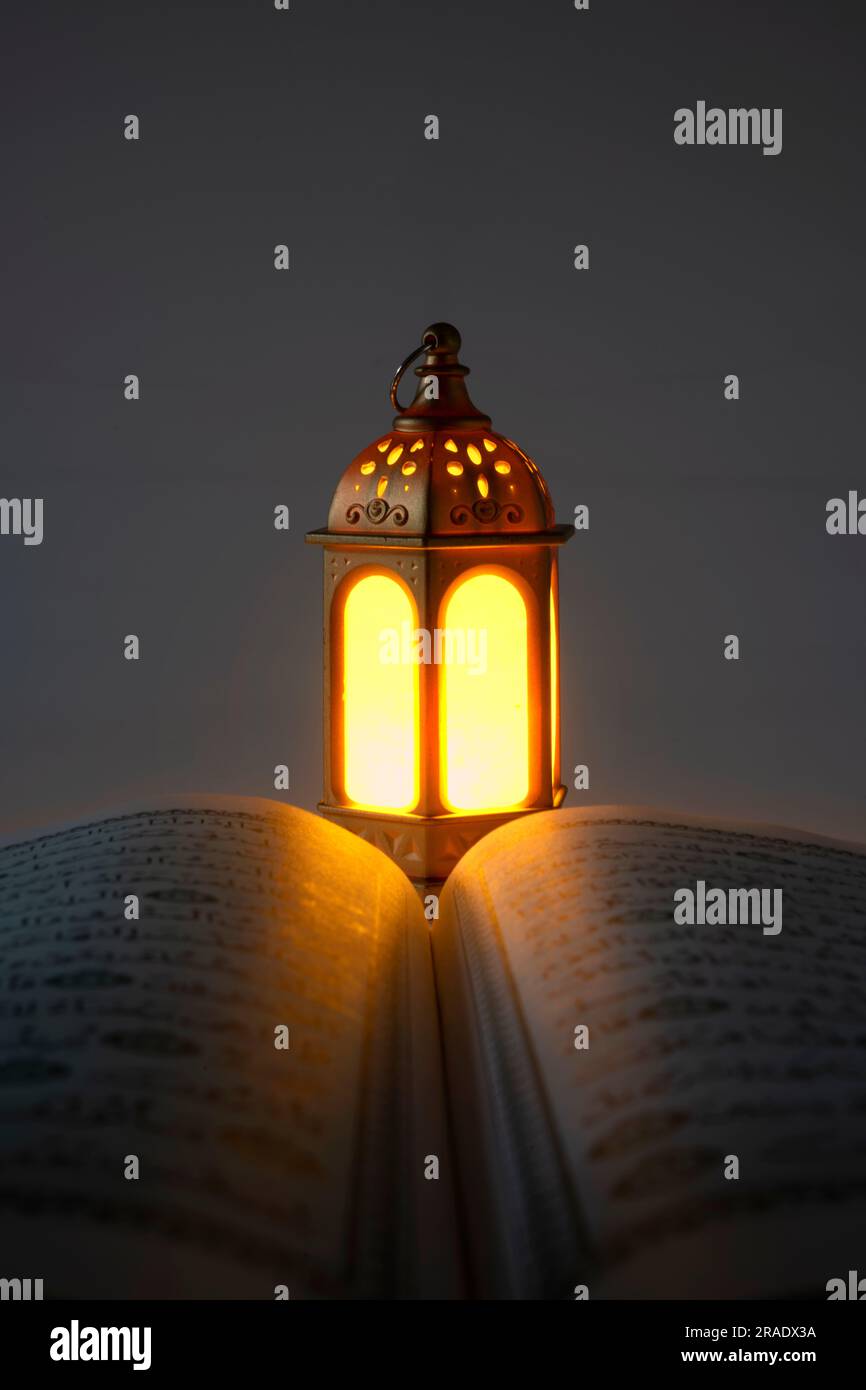 Quran and Arabic lamp with bright light with dark background Stock ...