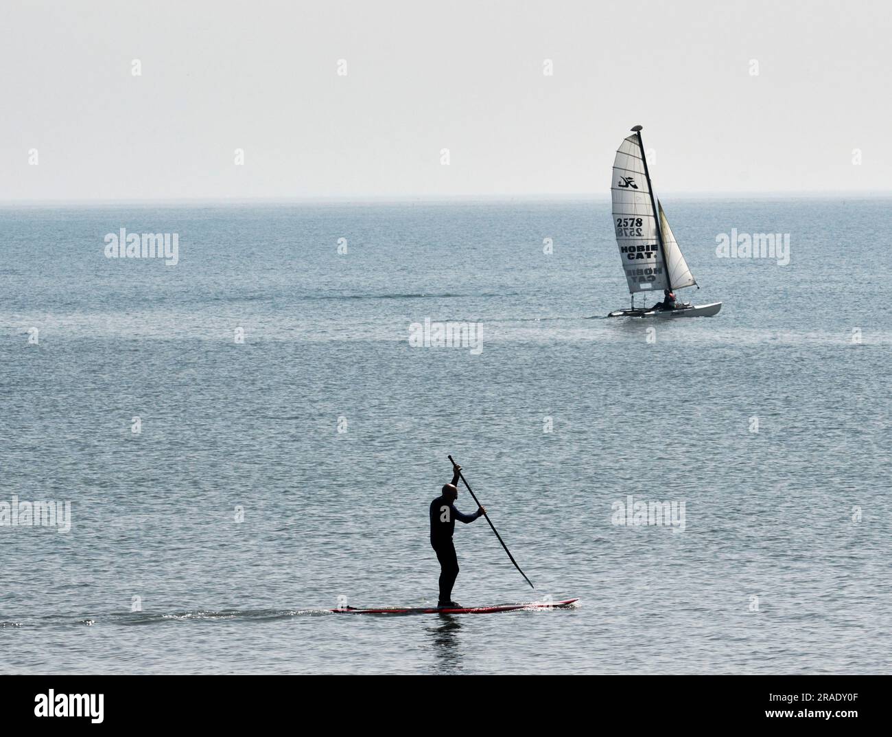 Paddle boarder and sailing boat at Filey, Yorkshire East Coast ...