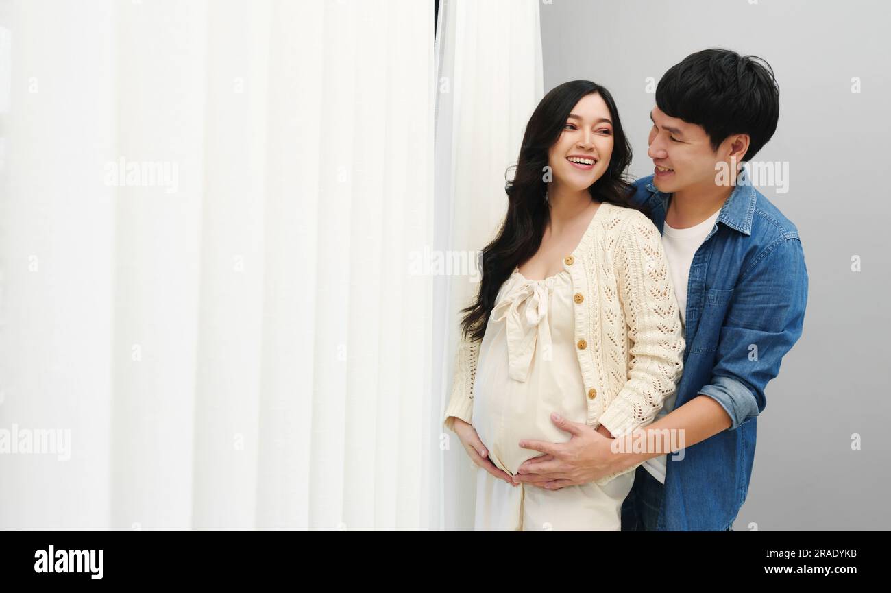 married couple is expecting baby. man embracing and talking with his ...