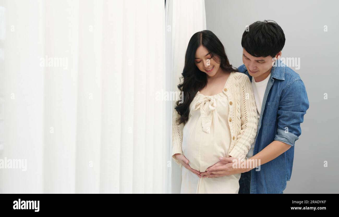 married couple is expecting baby. man embraces his pregnant wife on a ...