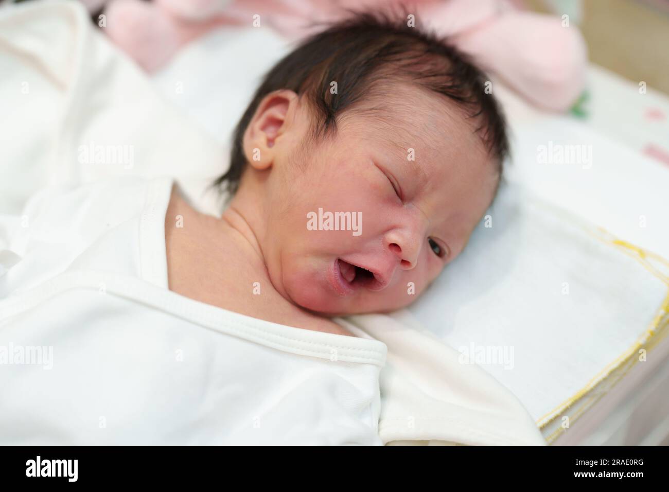 happy newborn baby laying in the infant bassinet basket at hospital ...
