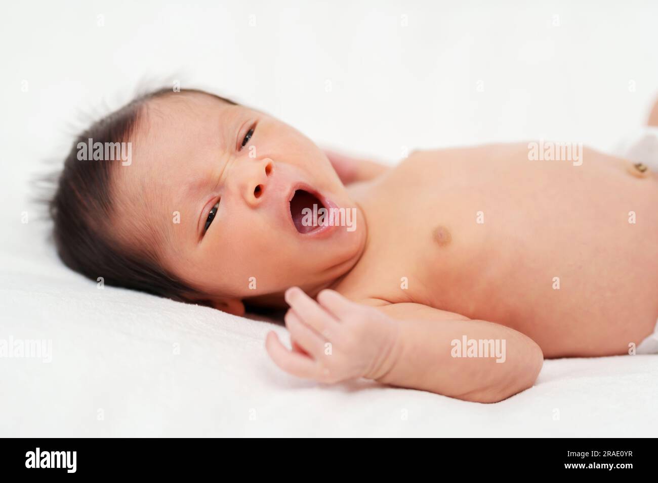 newborn baby yawning on a bed Stock Photo - Alamy