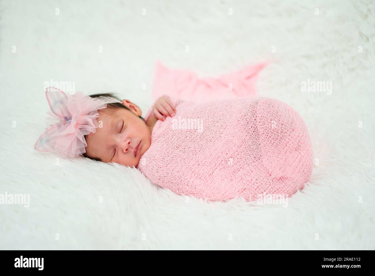 newborn baby girl sleeping in cloth wrap blanket on a bed Stock Photo - Alamy