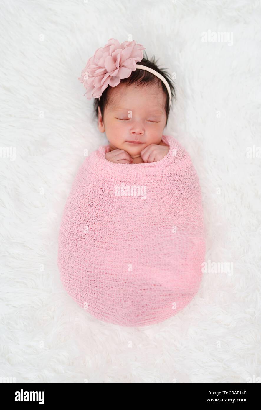 happy newborn baby girl sleeping in cloth wrap blanket on a bed Stock Photo - Alamy