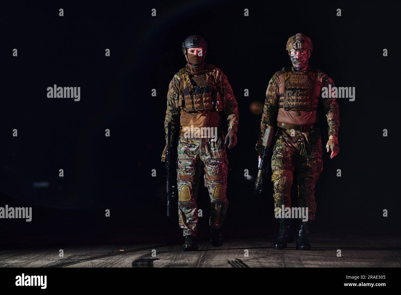 Two professional soldiers marching through the dark of night on a ...