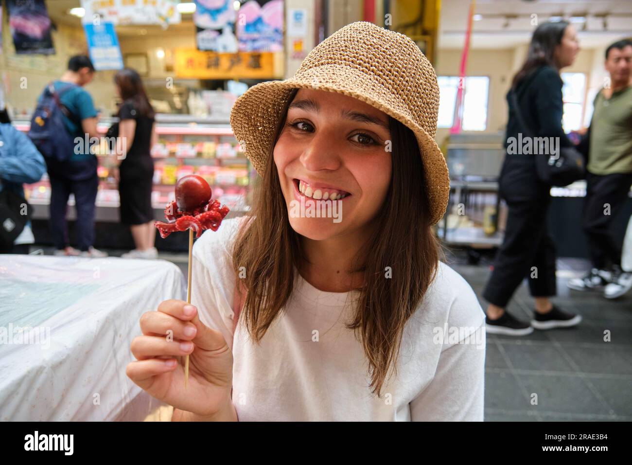 Tourist holds tako tamago, octopus with an egg into its head, at Osaka ... Tourist holds tako tamago, octopus with an egg into its head, at Osaka ...