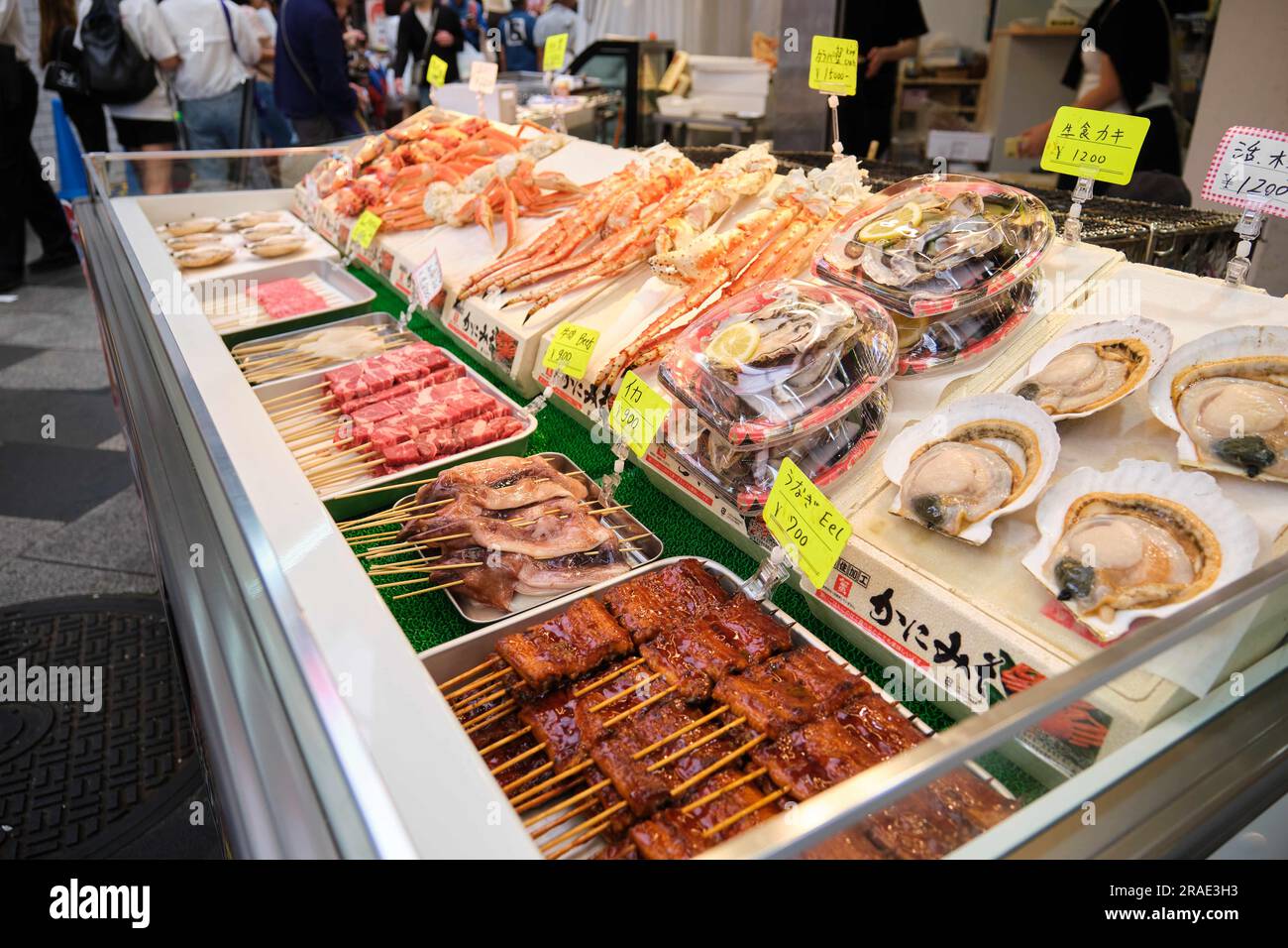 Fresh crab legs, seafood, eel and meat skewers in a Osaka market, Japan ...