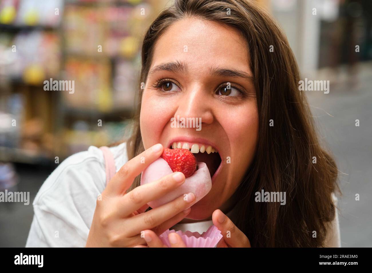 Tourist eating ichigo daifuku or strawberry mochi at Osaka, Japan Stock ...