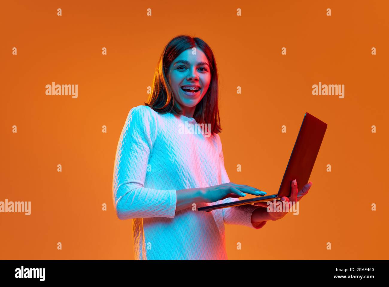 Portrait of beautiful, smiling happy, girl standing with laptop ...