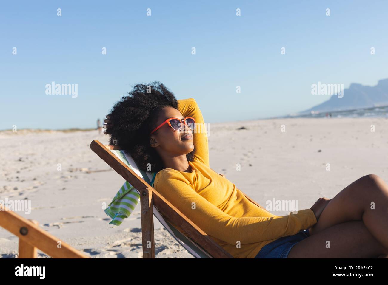 Happy African American Woman In Sunglasses Relaxing In Deckchair On