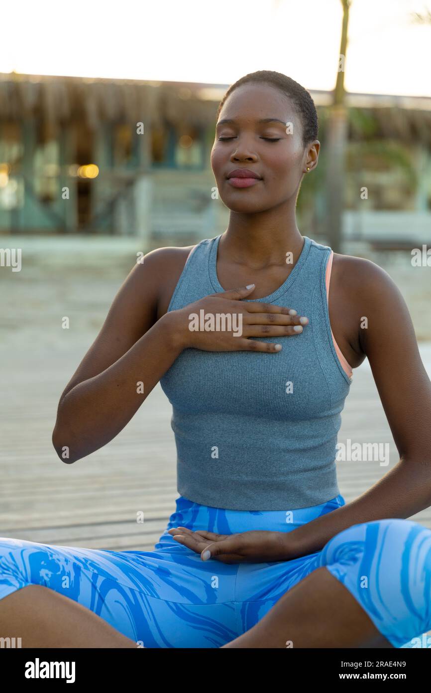 Happy african american woman practicing yoga meditation sitting with ...