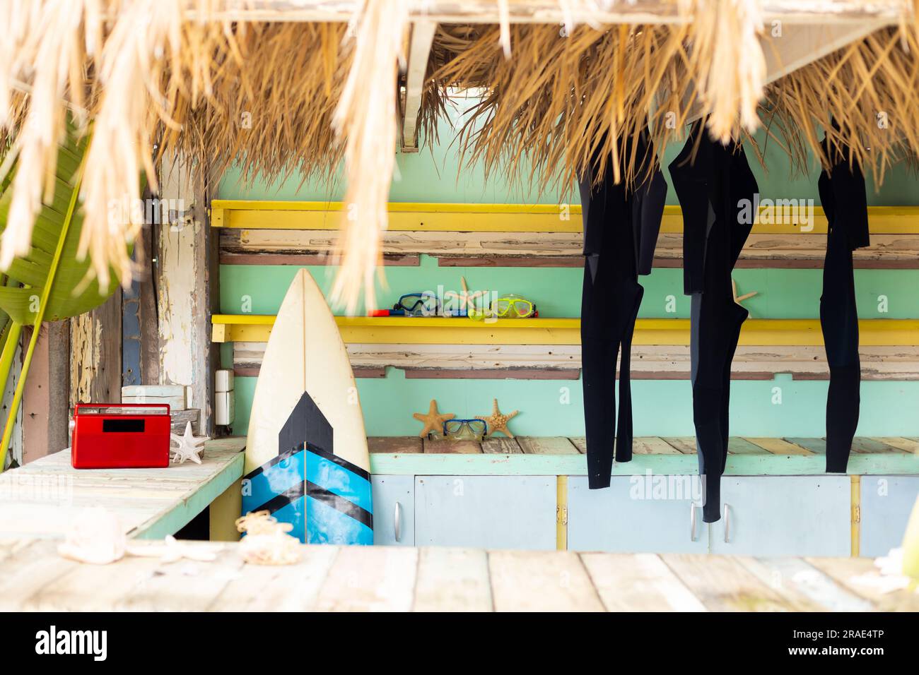 Counter of sunny surf hire shop on beach with radio, surfboard and ...
