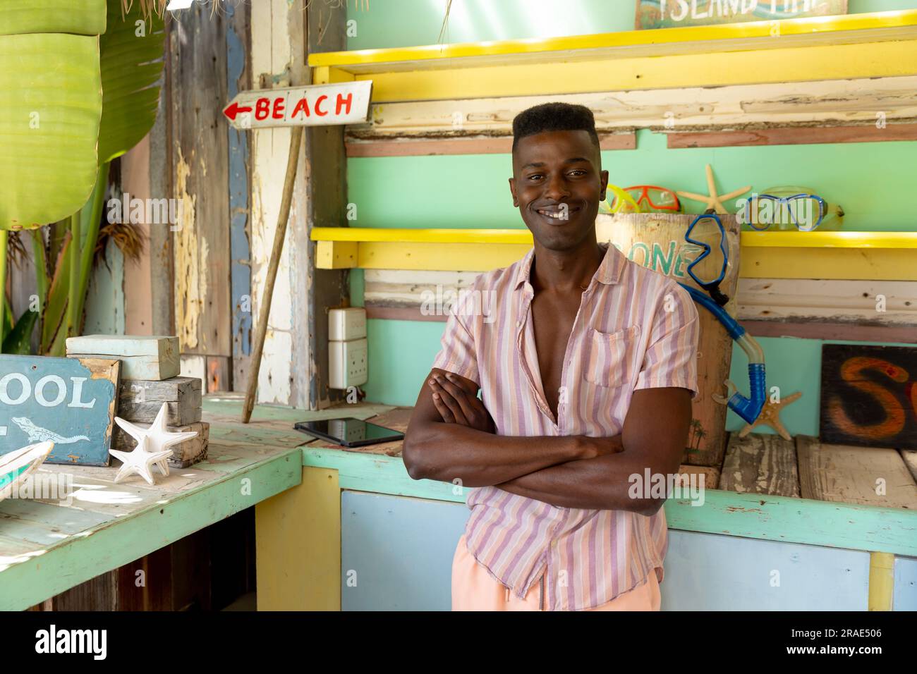 Portrait of happy african american man standing behind counter of surf ...