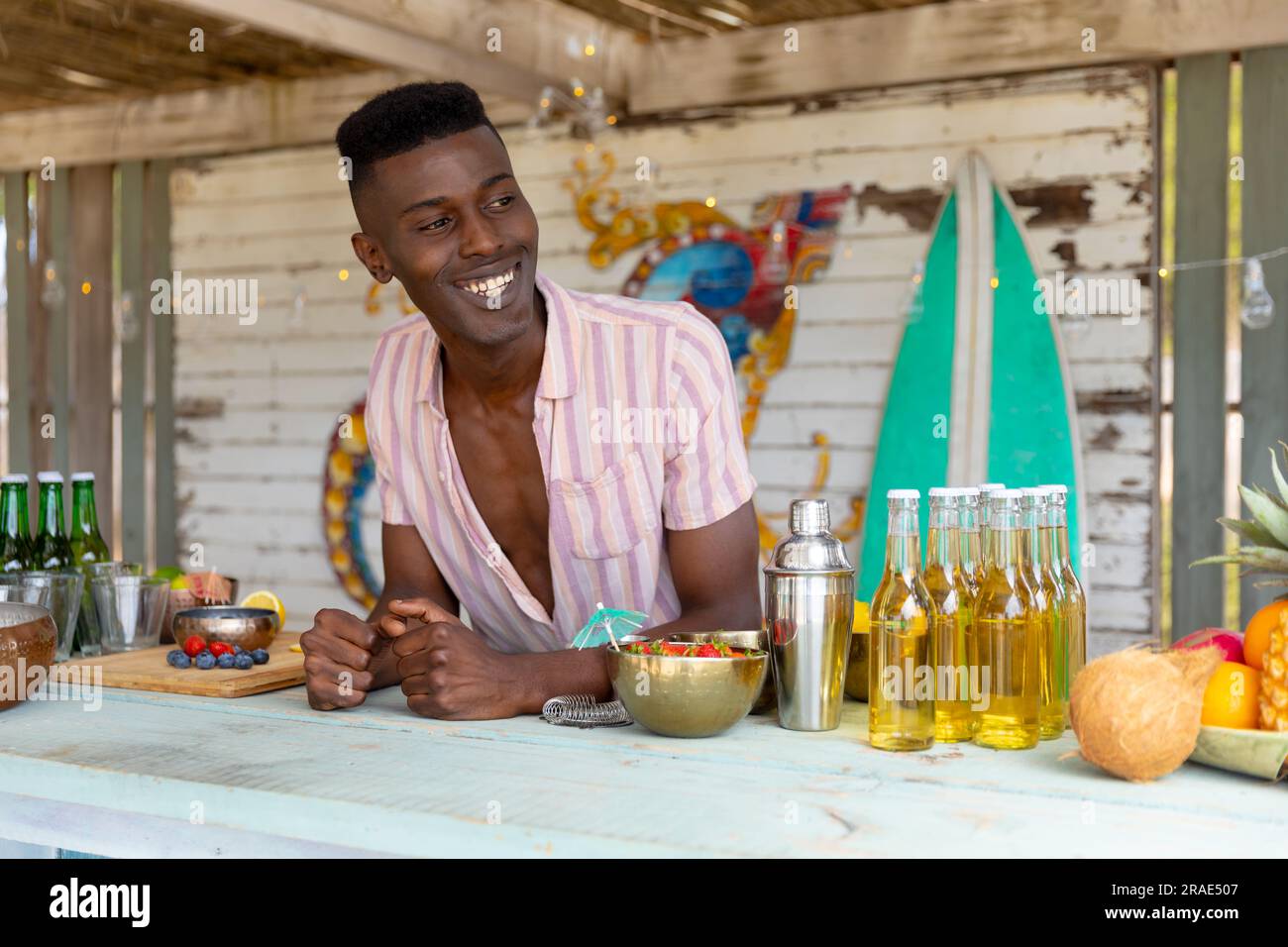 Happy african american male bartender smiling behind the counter at ...