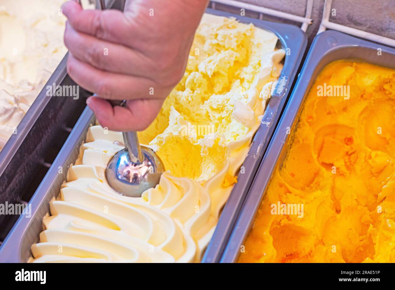 woman's hand picking vanilla ice cream by weight with a special ice cream spoon Stock Photo - Alamy