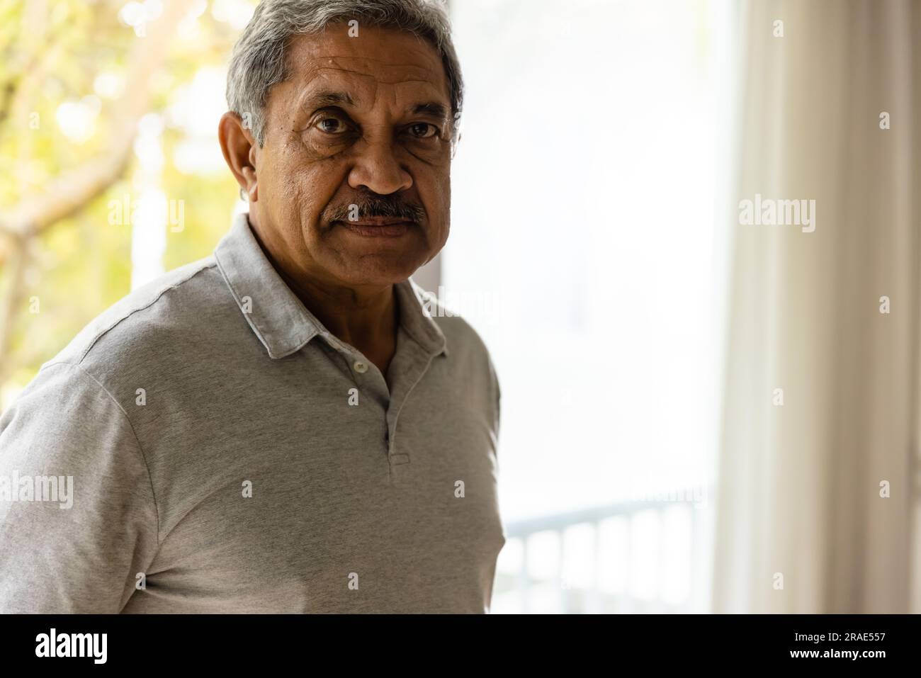 Portrait of senior biracial man staying by window Stock Photo - Alamy